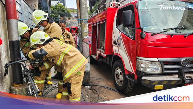 Petugas Damkar Bantu Pesepeda yang Gemboknya Tersangkut di Tiang Utilitas