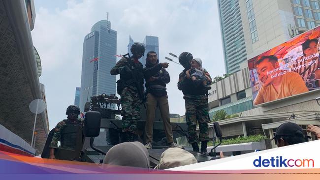 Warga Berfoto di Atas Tank TNI Saat Pawai Alutsista Melintas di Bundaran HI