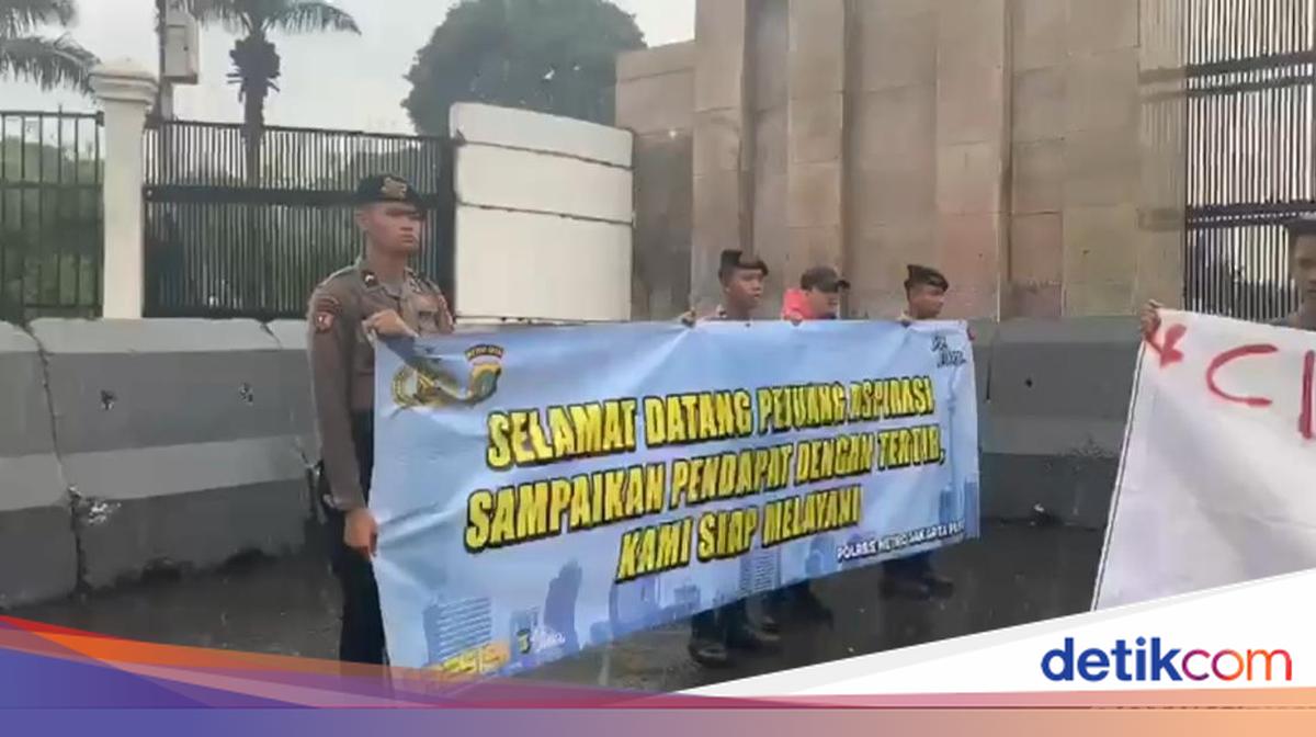 Momen Polisi Kawal Demonstrasi di Gedung DPR di Tengah Hujan