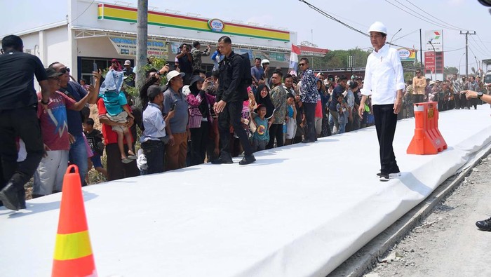 Sambil Jongkok Jokowi Cek Perbaikan Jalan Rusak di Lampung Telan Rp 800 M