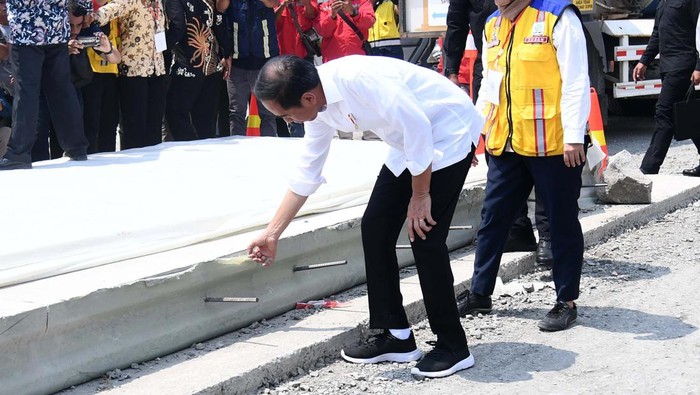 Sambil Jongkok Jokowi Cek Perbaikan Jalan Rusak di Lampung Telan Rp 800 M