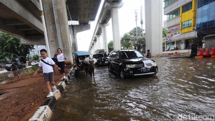 Potret Pengendara Nekat Terobos Banjir di Kelapa Gading Potret Pengendara Nekat Terobos Banjir di Kelapa Gading